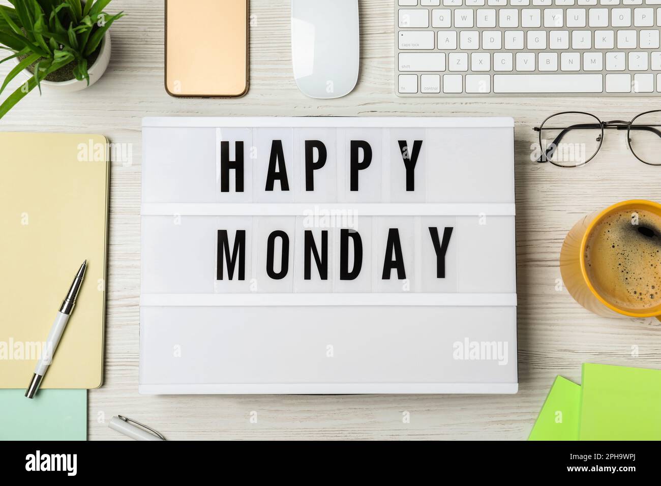 Flat lay composition of lightbox with phrase Happy Monday at workplace ...