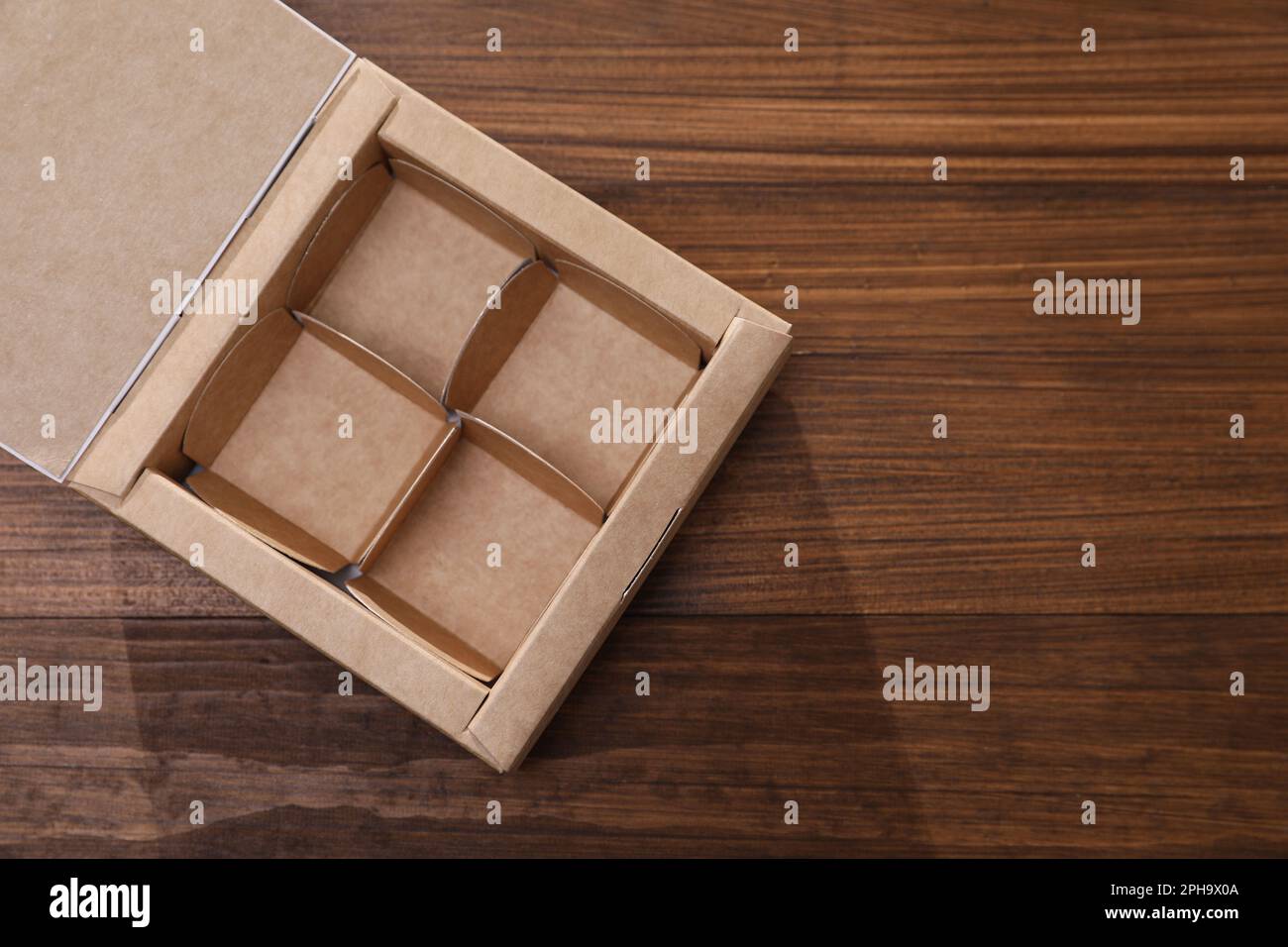 Empty packaging box with dividers on wooden table, top view. Space for ...