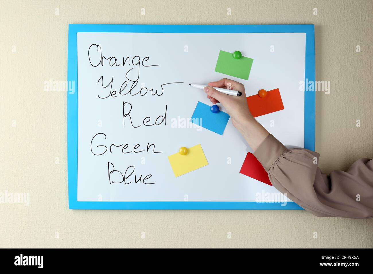 Woman matching colors on white board, closeup. ABA therapy concept ...