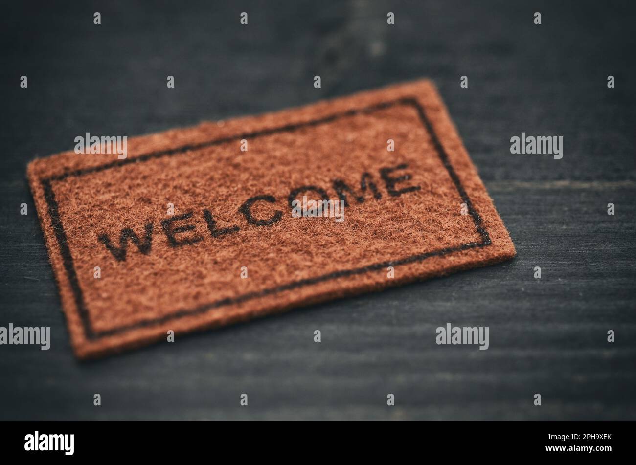 Old Welcome door mat on black wooden background, welcome concept, home ...
