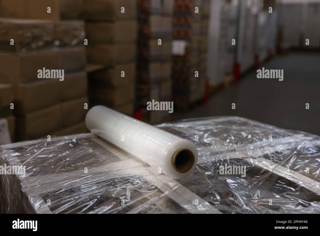 Roll of stretch wrap on box in warehouse Stock Photo - Alamy