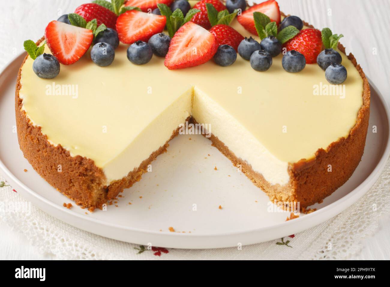 New York cheesecake decorated with berries with a cut out closeup ...