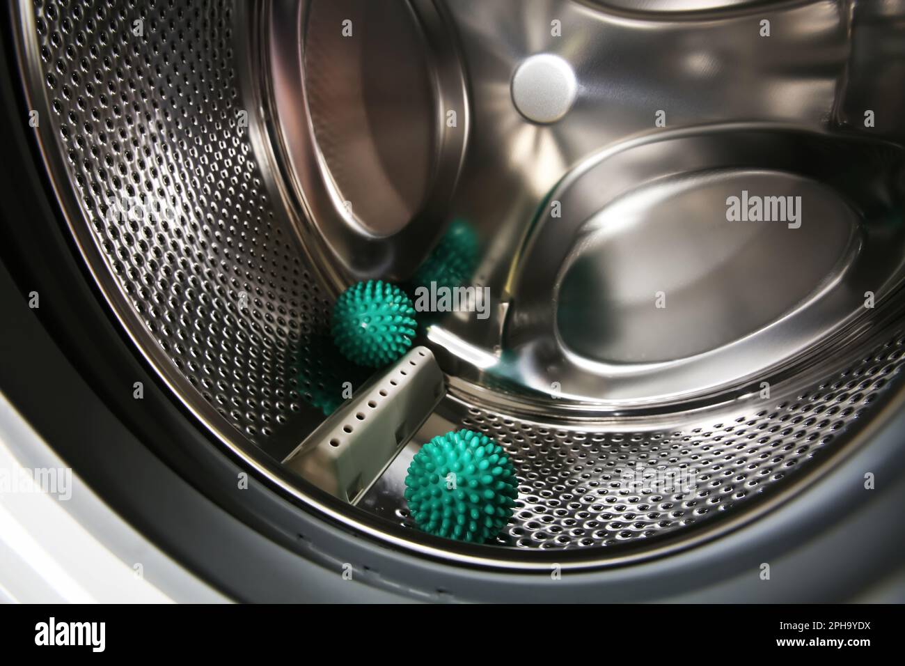 Green dryer balls in washing machine drum, closeup Stock Photo - Alamy