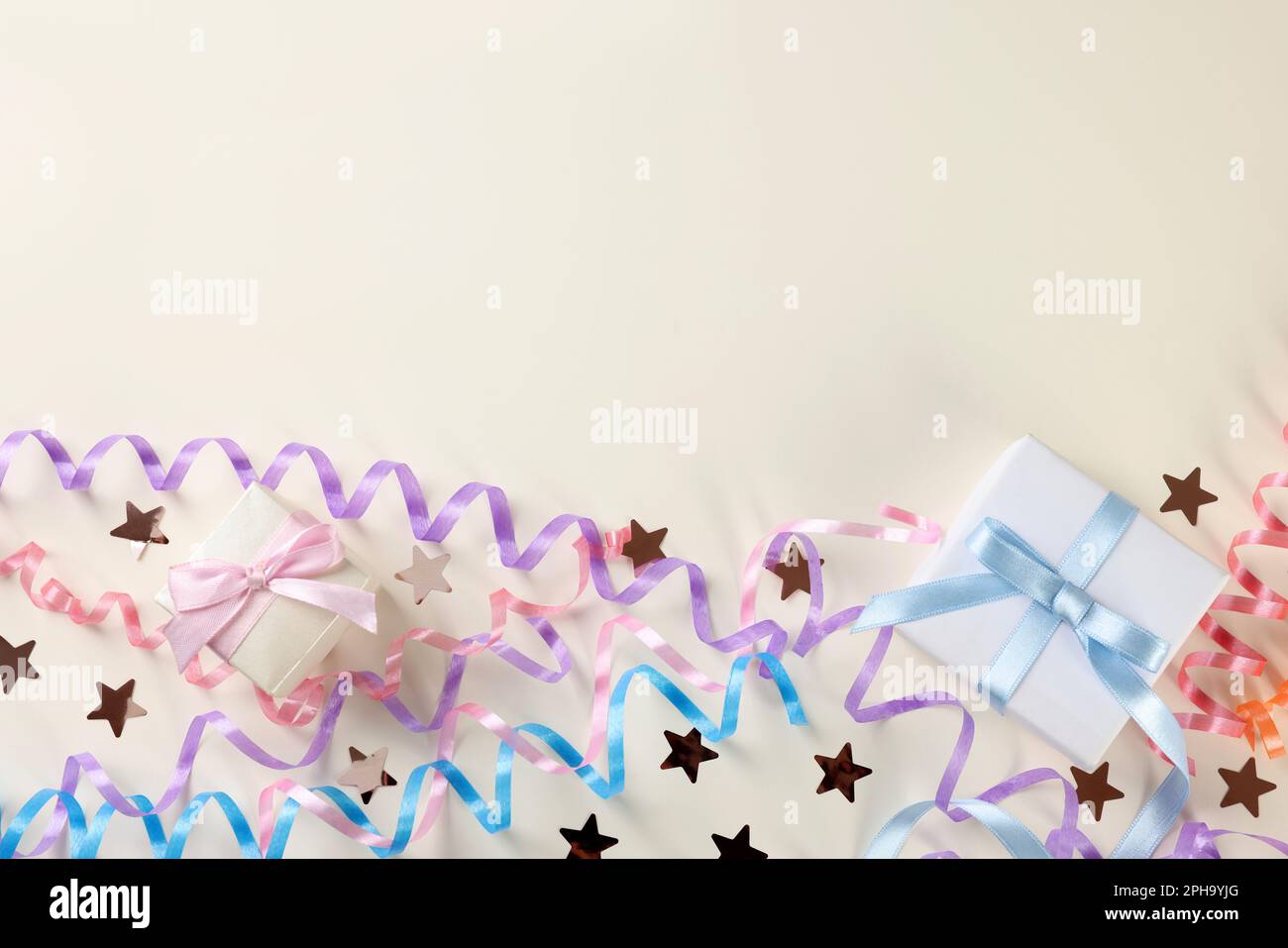 Colorful serpentine streamers, gift boxes and confetti on white ...