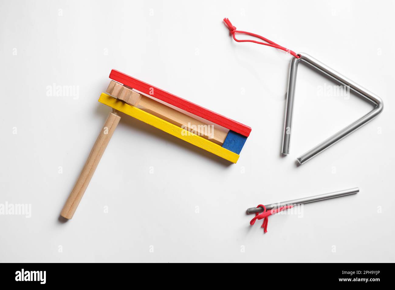 Wooden spinning ratchet and sound triangle on white background ...