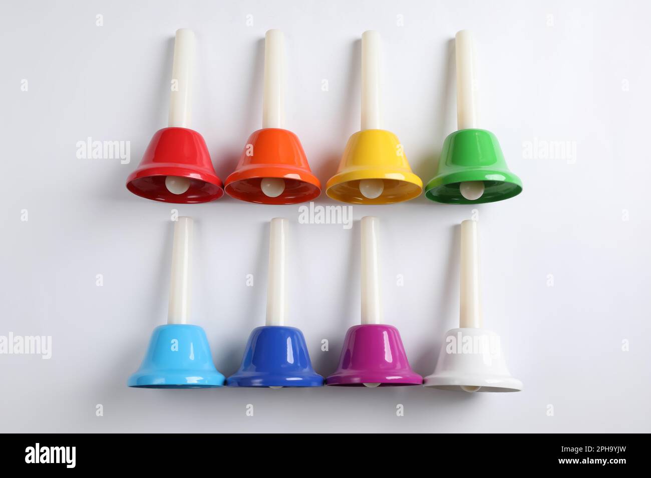 Set of bright metal hand bells on white background, top view ...