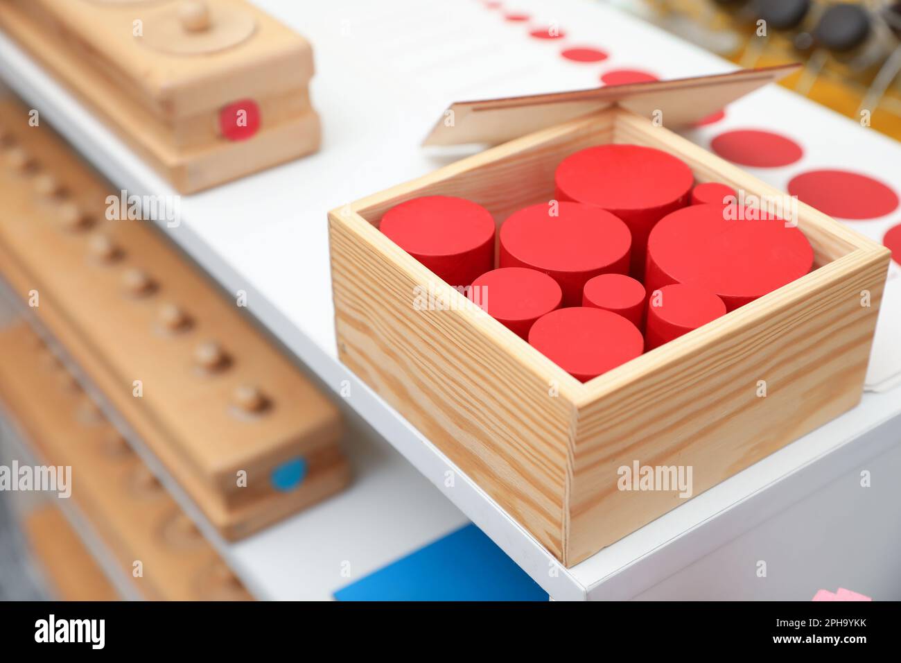 Set of wooden geometrical objects and other montessori toys on shelves ...