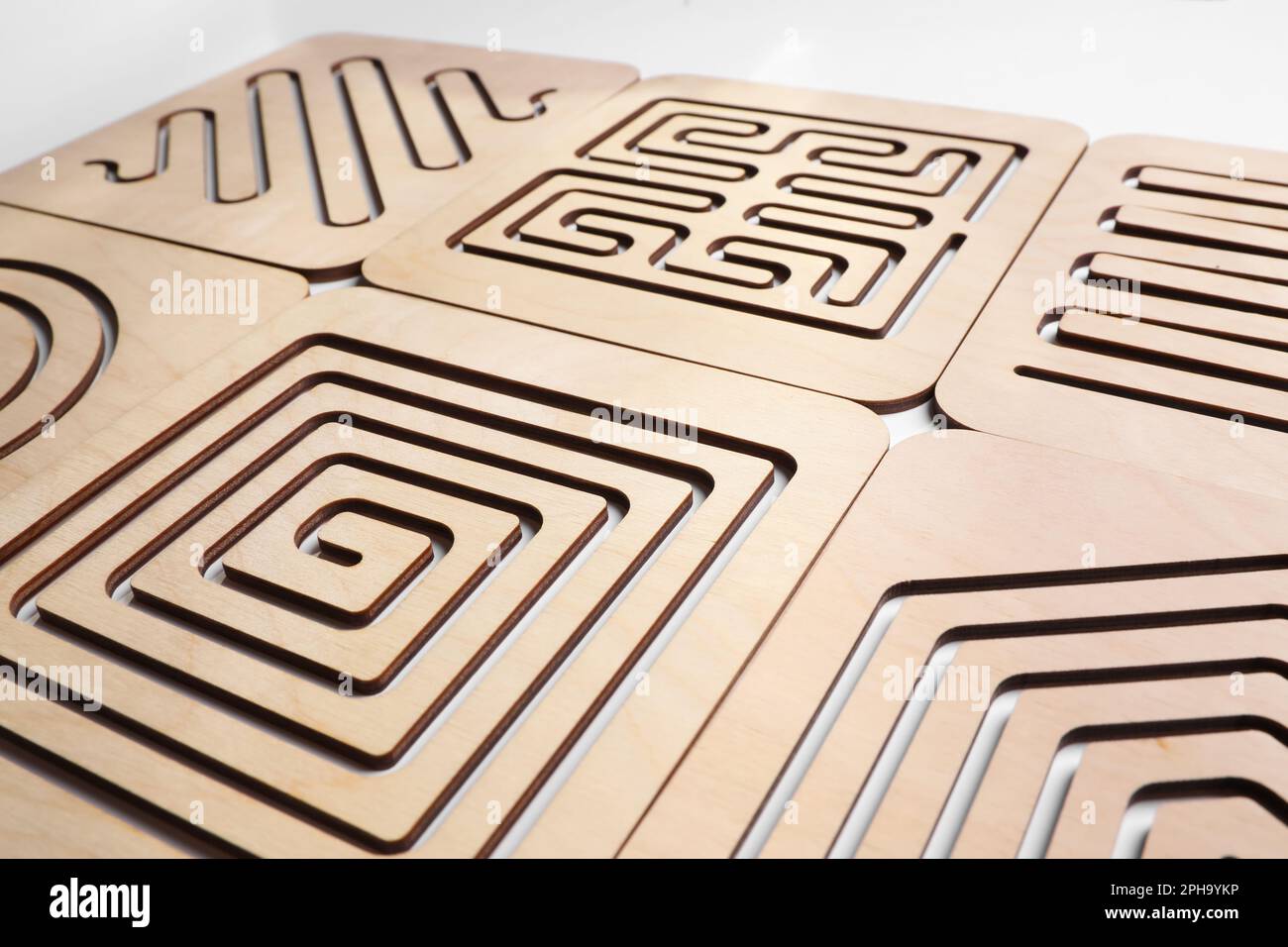 Wooden finger labyrinths on white background, closeup. Montessori toy ...