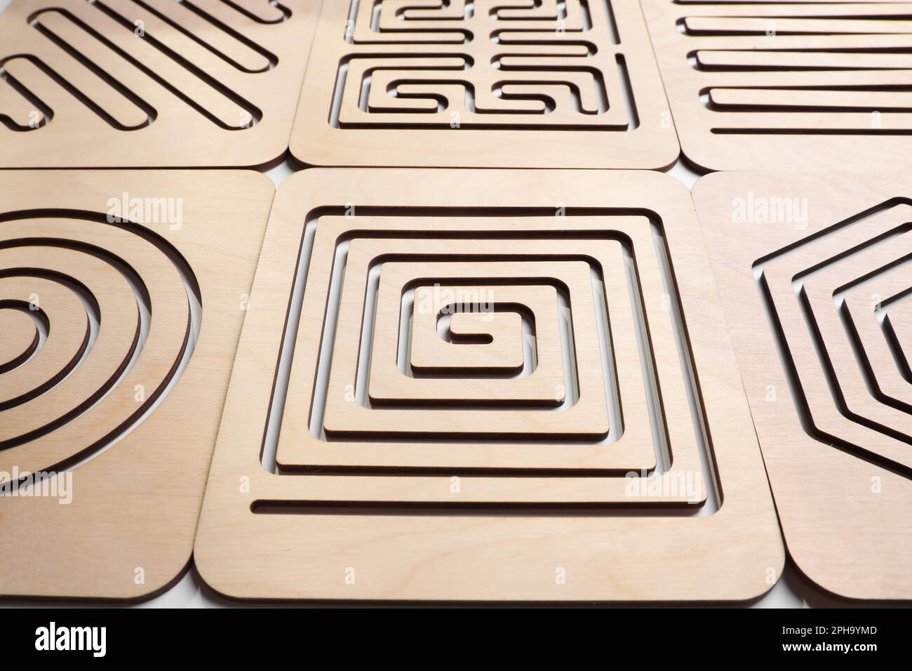 Wooden finger labyrinths on white background, closeup. Montessori toy ...