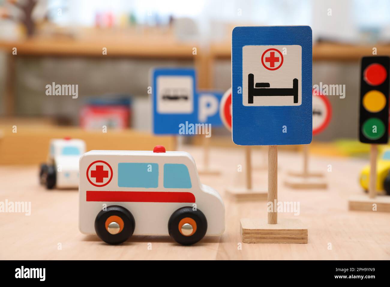 Different miniature road signs and cars on wooden table, closeup ...