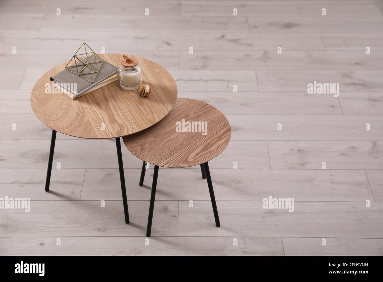 Wooden nesting tables with books and decor indoors Stock Photo - Alamy