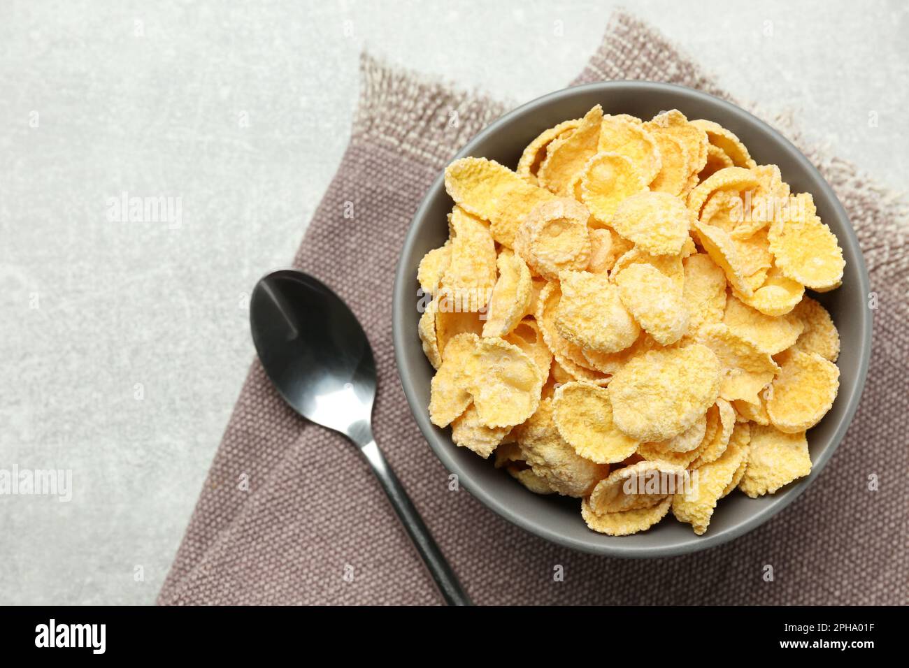 Bowl of sweet crispy corn flakes on light grey table, flat lay ...