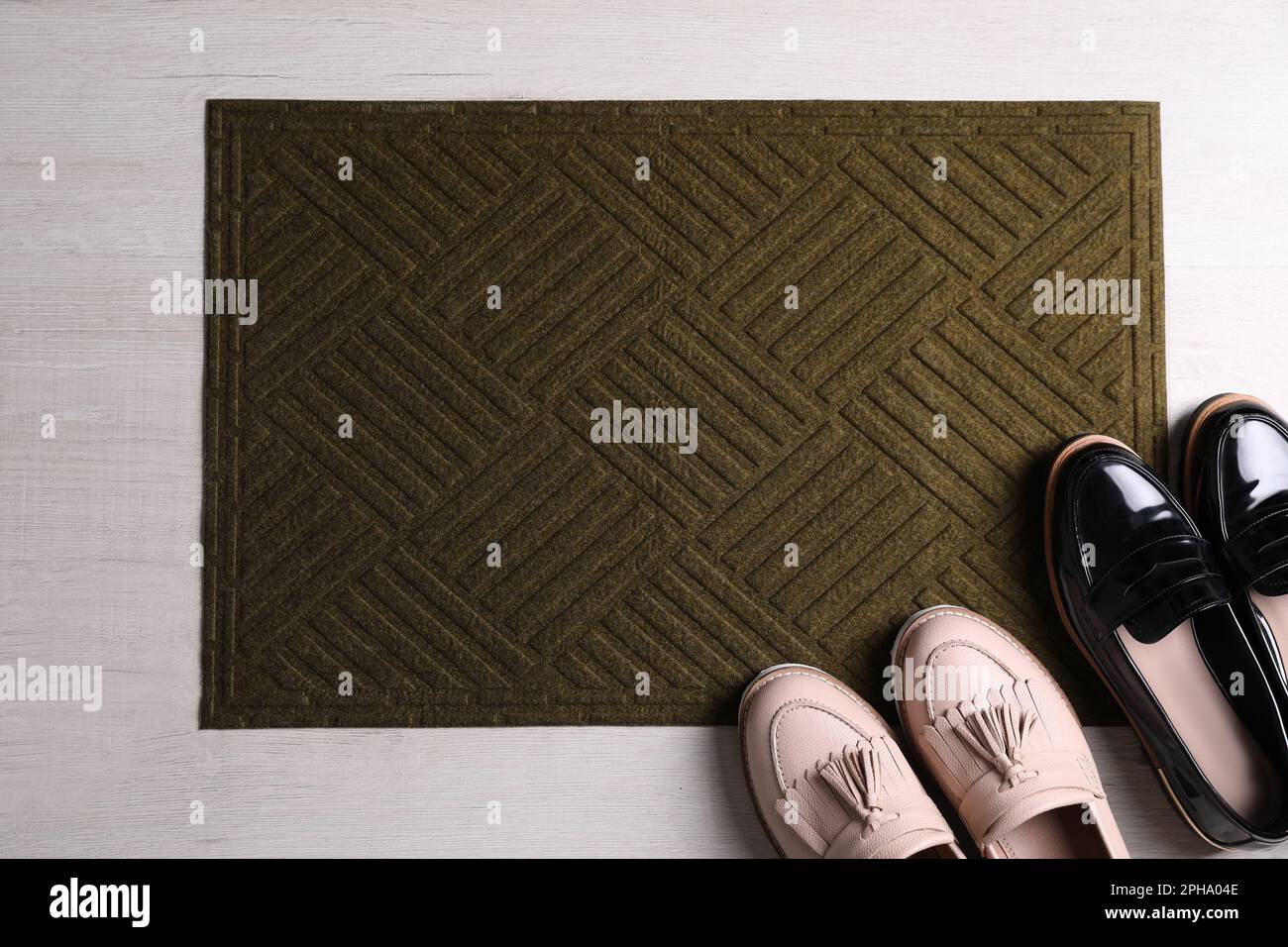New clean door mat and shoes on floor, flat lay Stock Photo - Alamy