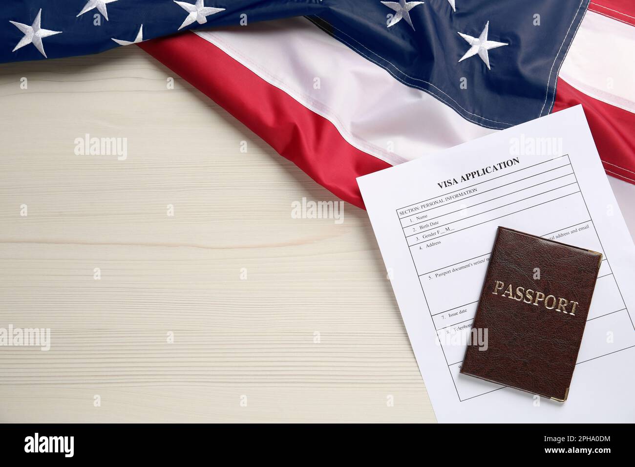American flag, visa application form and passport on white wooden table ...