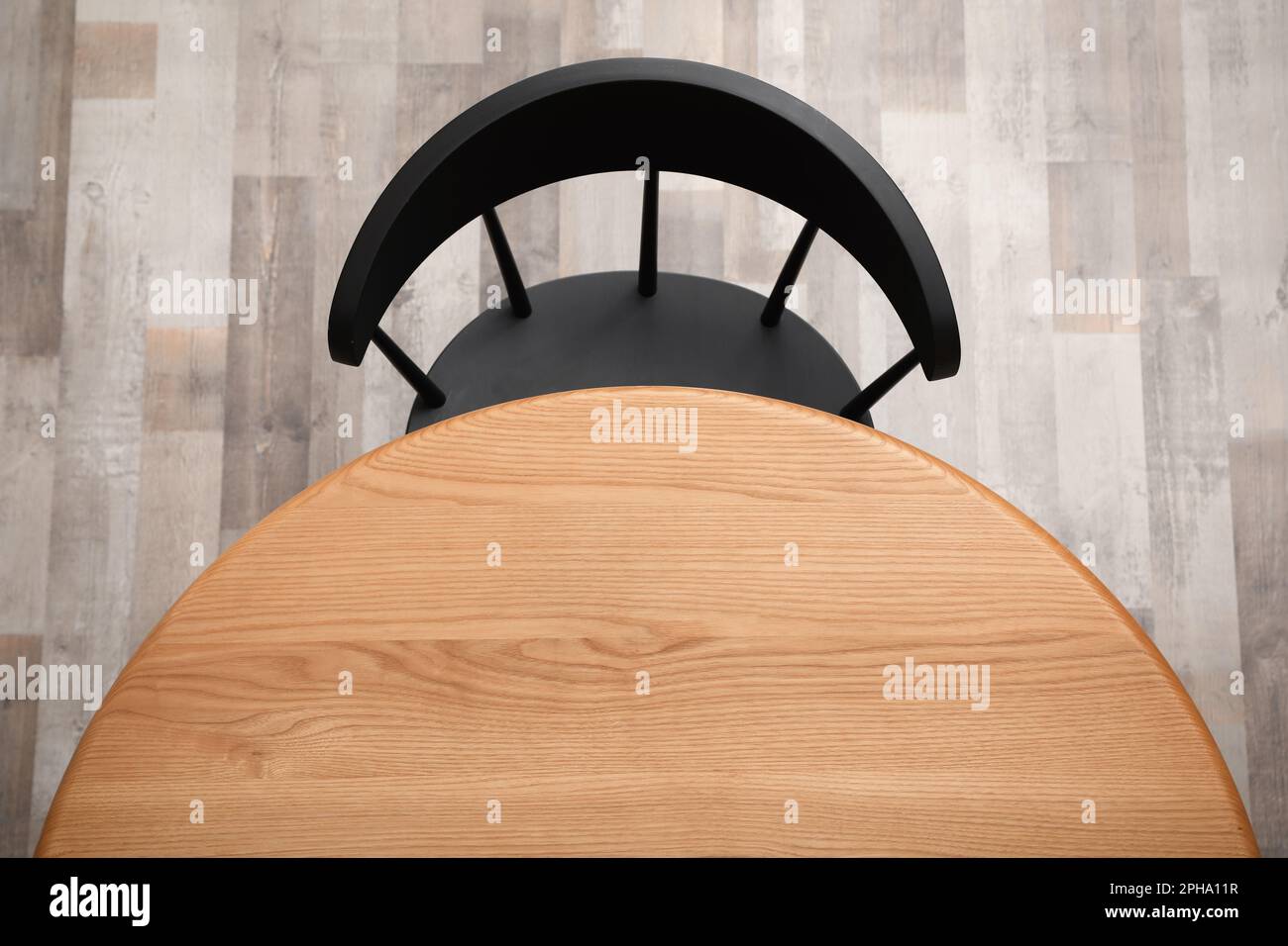 Round wooden table and black chair indoors, top view Stock Photo - Alamy