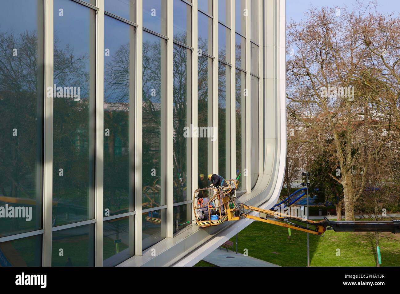 Workers cleaning windows from a self-propelled telescopic boom lift at ...