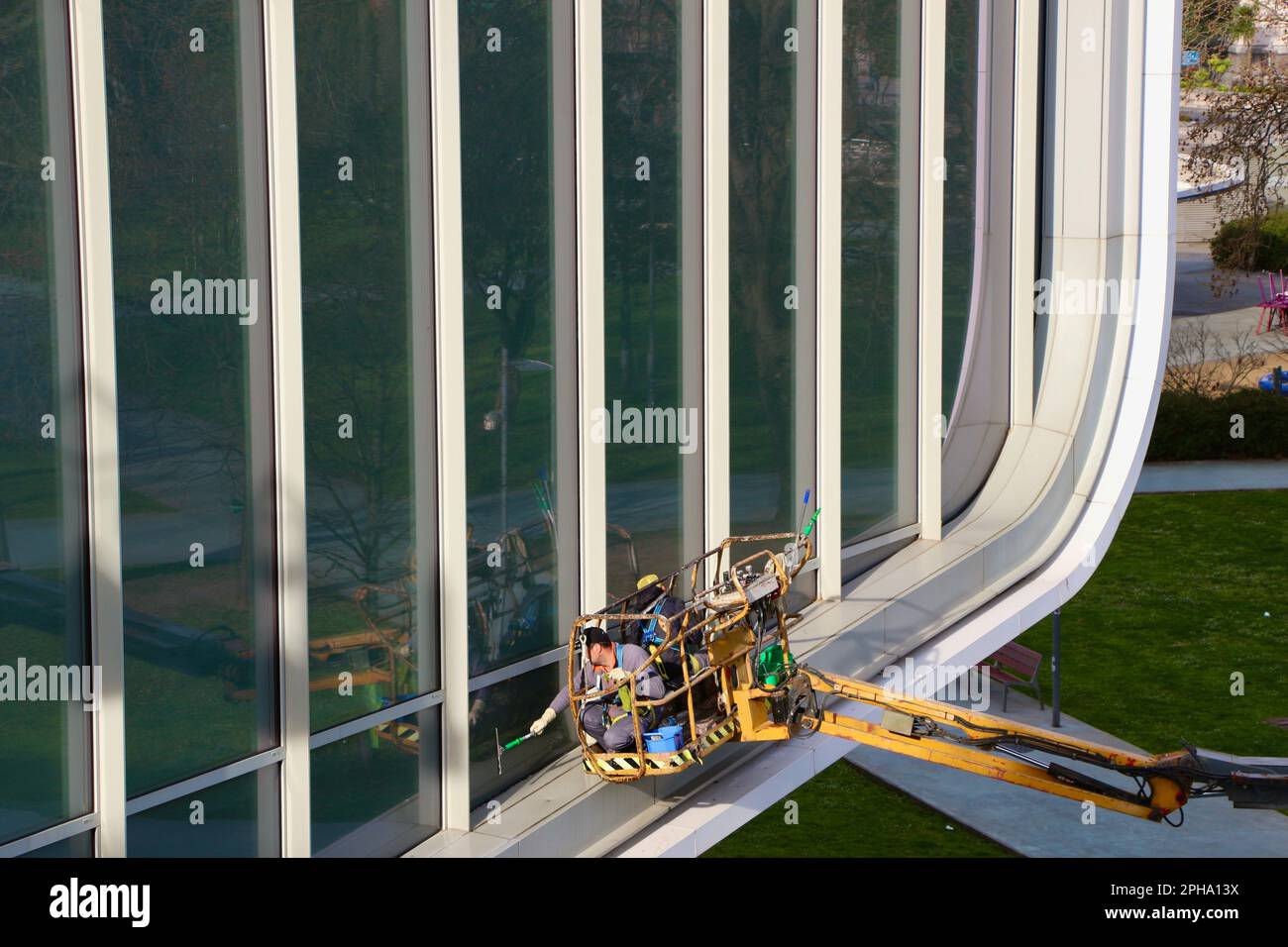 Workers cleaning windows from a self-propelled telescopic boom lift at ...