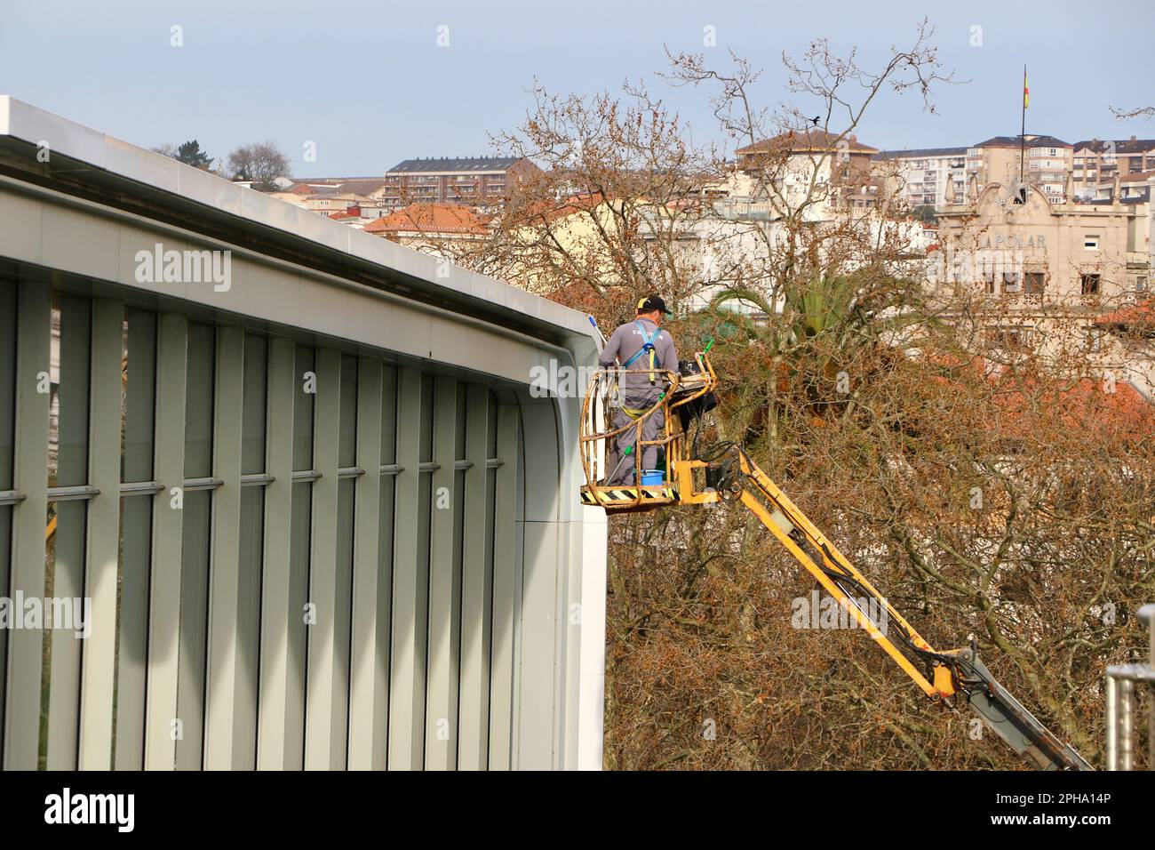 Workers cleaning windows from a self-propelled telescopic boom lift at ...