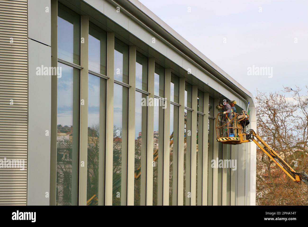 Workers cleaning windows from a self-propelled telescopic boom lift at ...