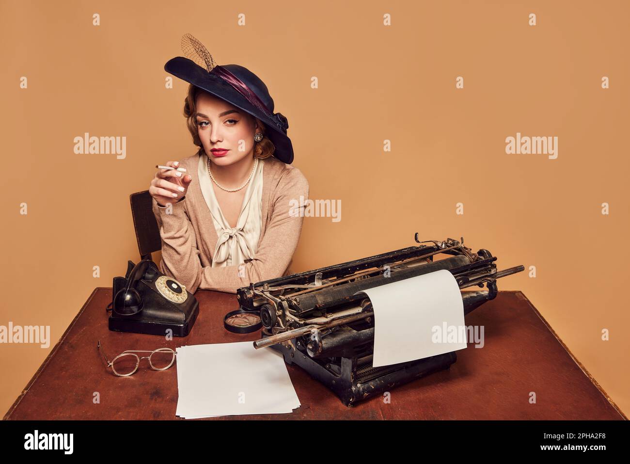 Attractive woman writer wearing old-fashioned clothes sitting at table ...