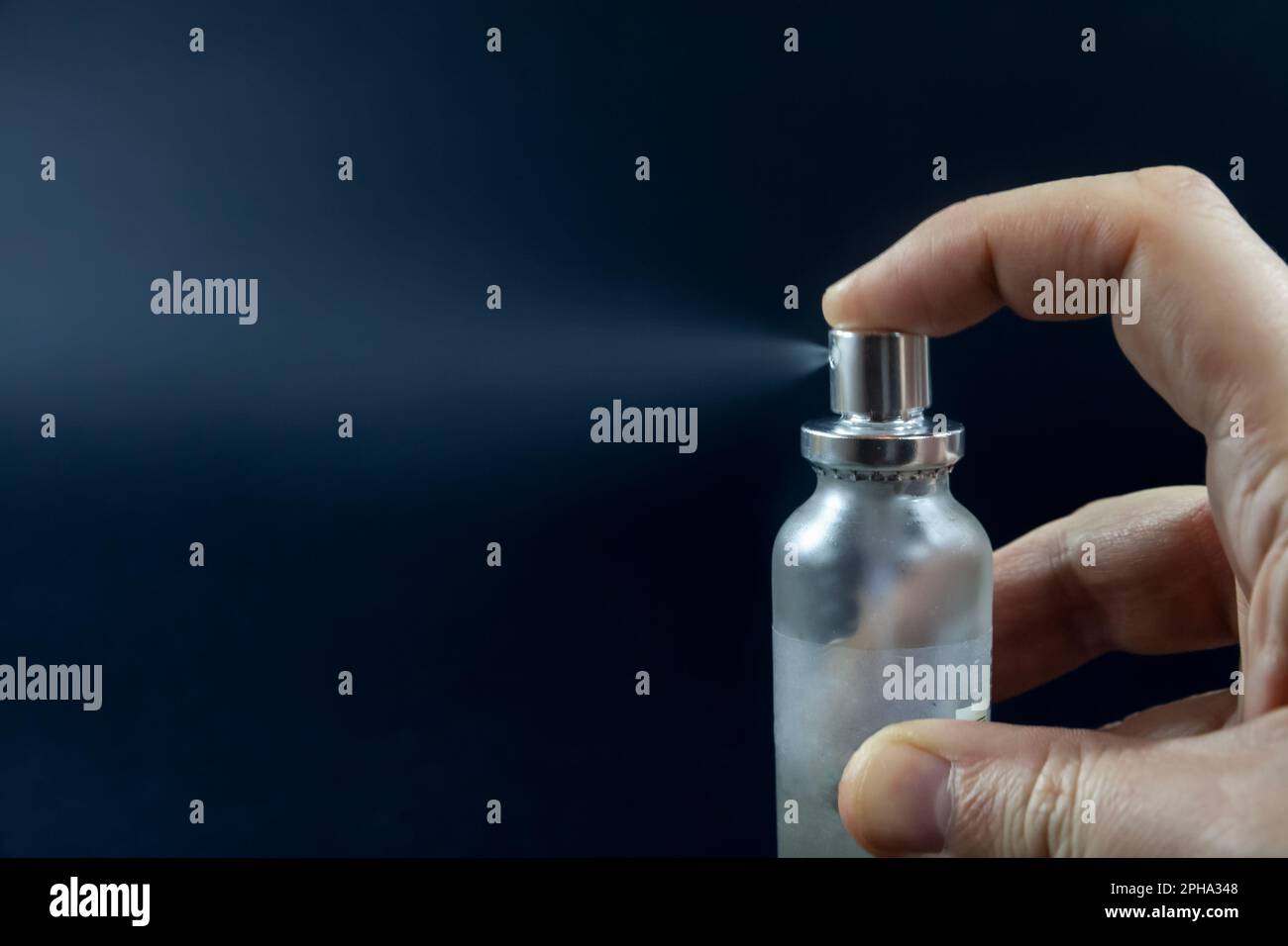 Picture of a small perfume bottle spraying fragrance, being pushed by ...