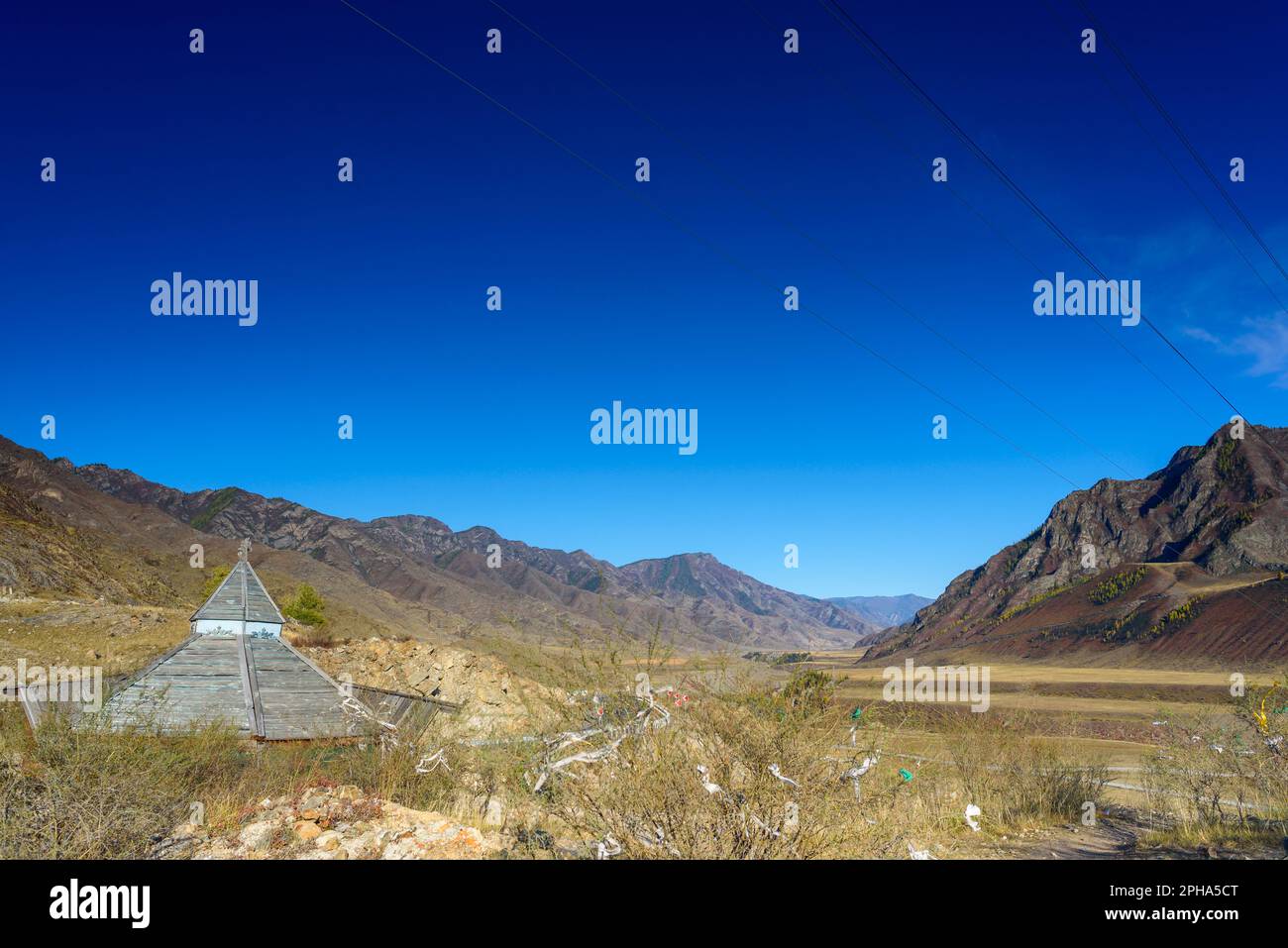 Bushes with strips of material solomaand a house with a round roof in ...