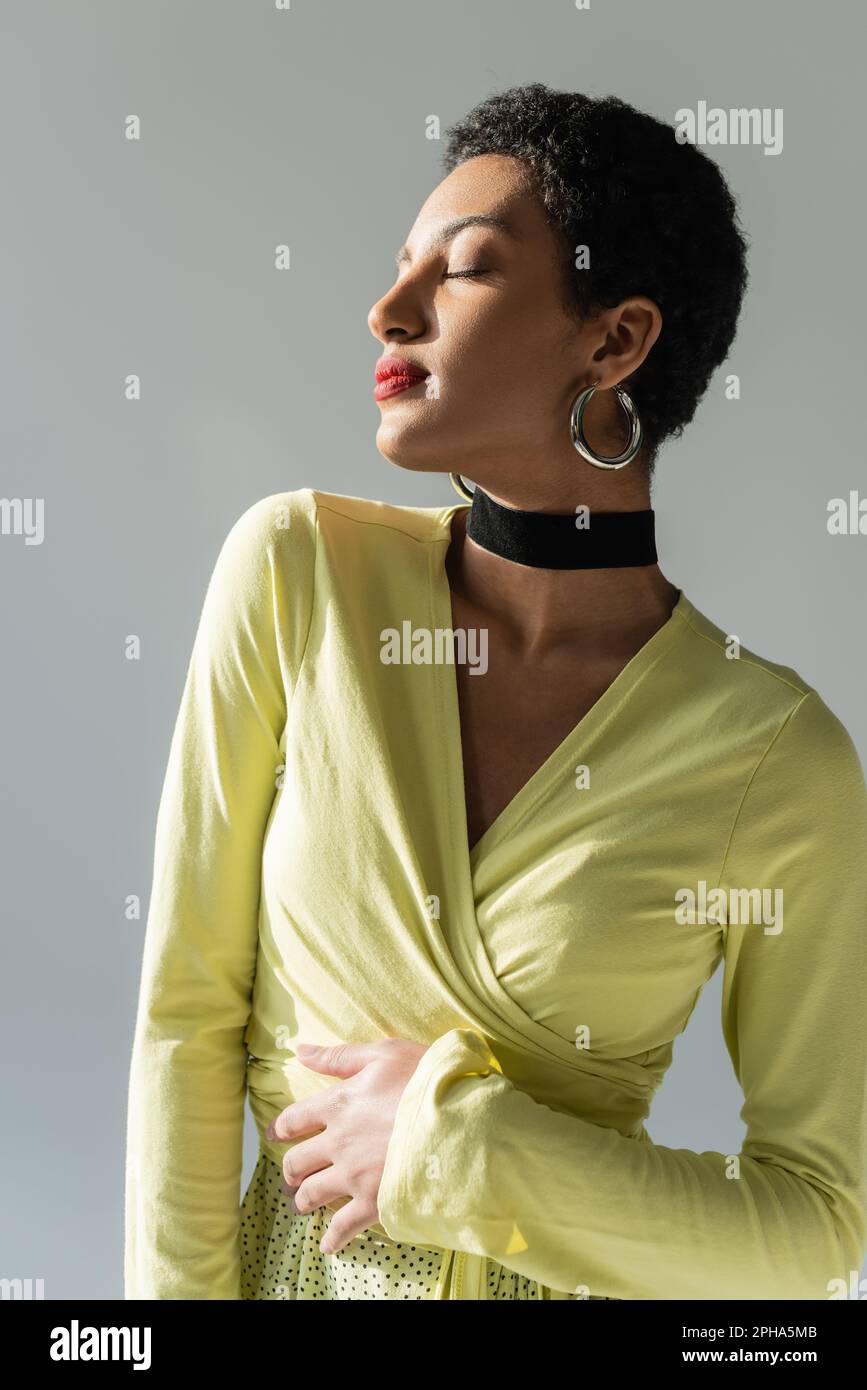 Portrait of young african american model posing in sunlight isolated on ...