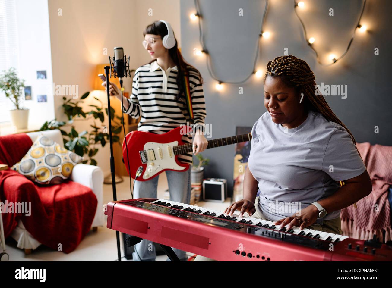 Young women recording song in studio, they singing songs and playing ...