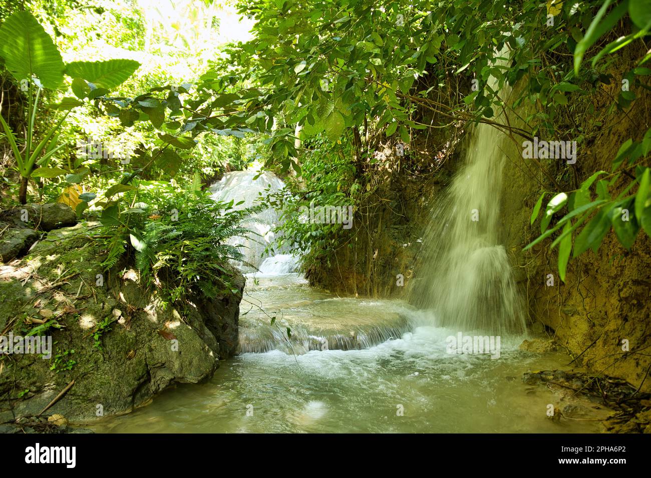 The idyllic Lugnason Waterfalls in Siquijor in the Philippines that flow into a natural pool of ...