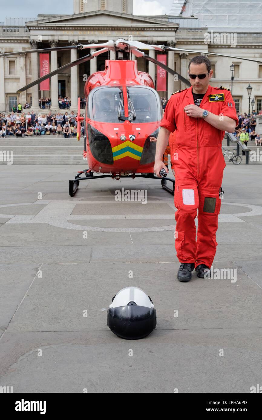 The pilot of a London Air Ambulance helicopter collects his helmet ...