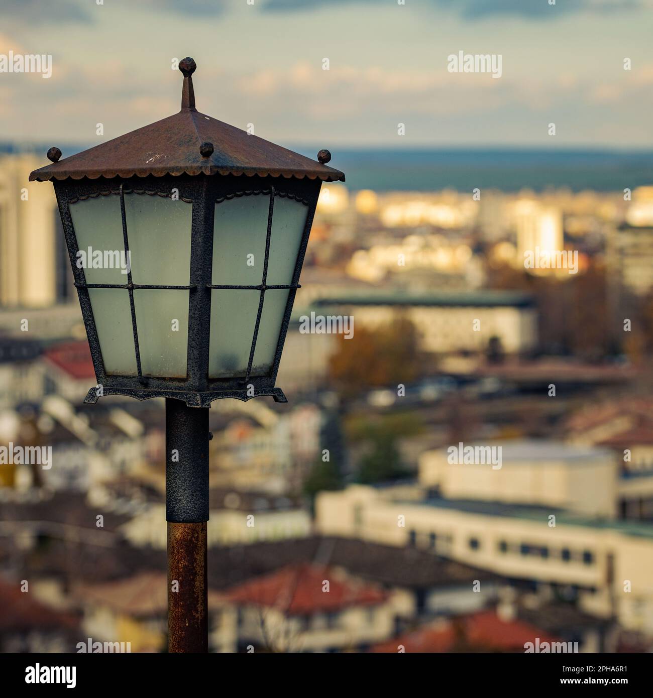 A close up of a street lamp post with a blurred background of a city ...