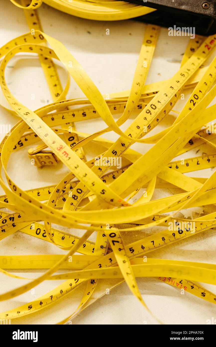 A vertical shot of a yellow measuring tape with a black line running ...