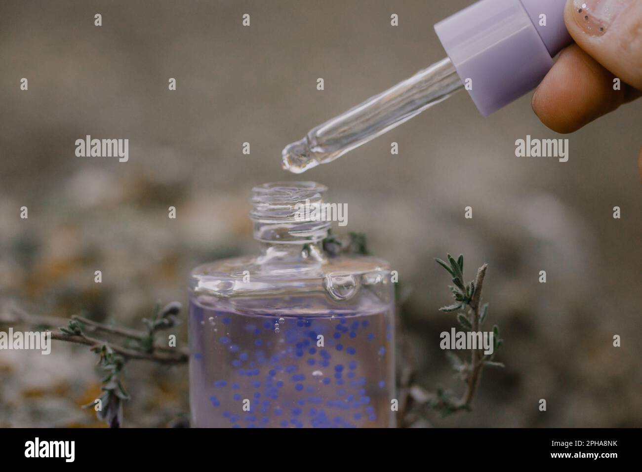 Cosmetic transparent glass dropper bottle, pipette in female hand ...