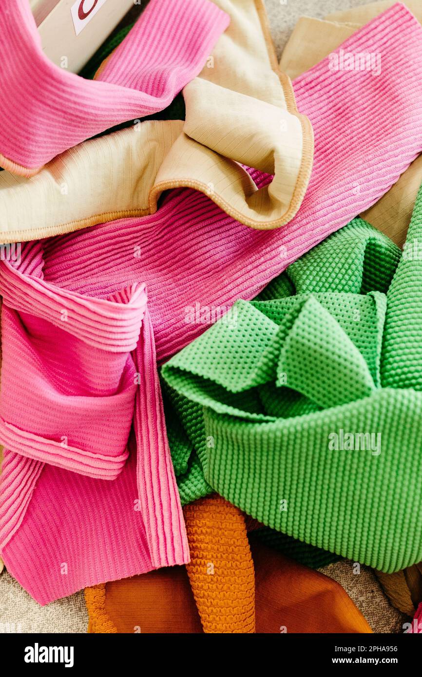 A vertical stock photo of a vibrant layered display of fabrics ...