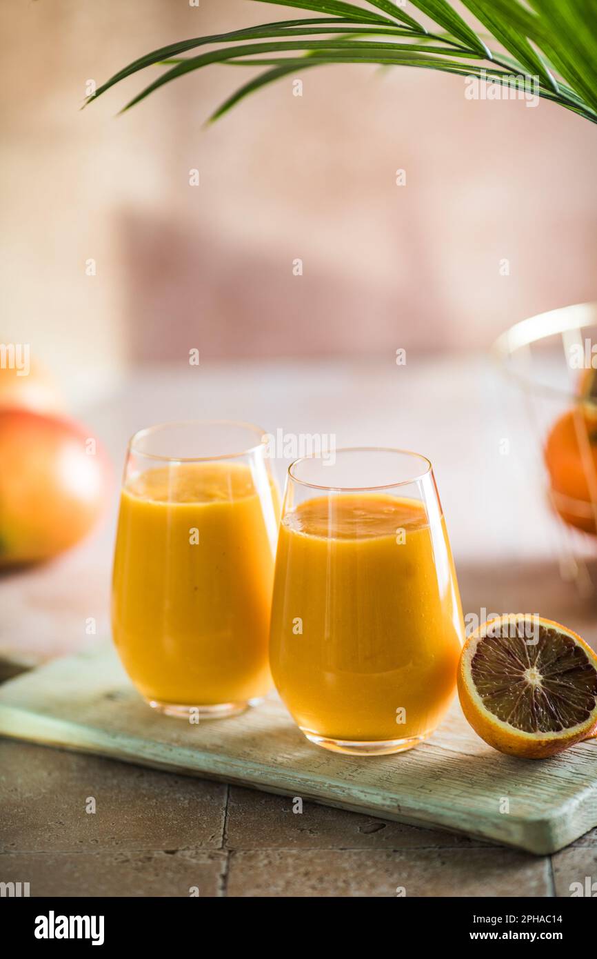 Two mango lassi or kesar milk in glasses. Indian healthy ayurvedic cold ...
