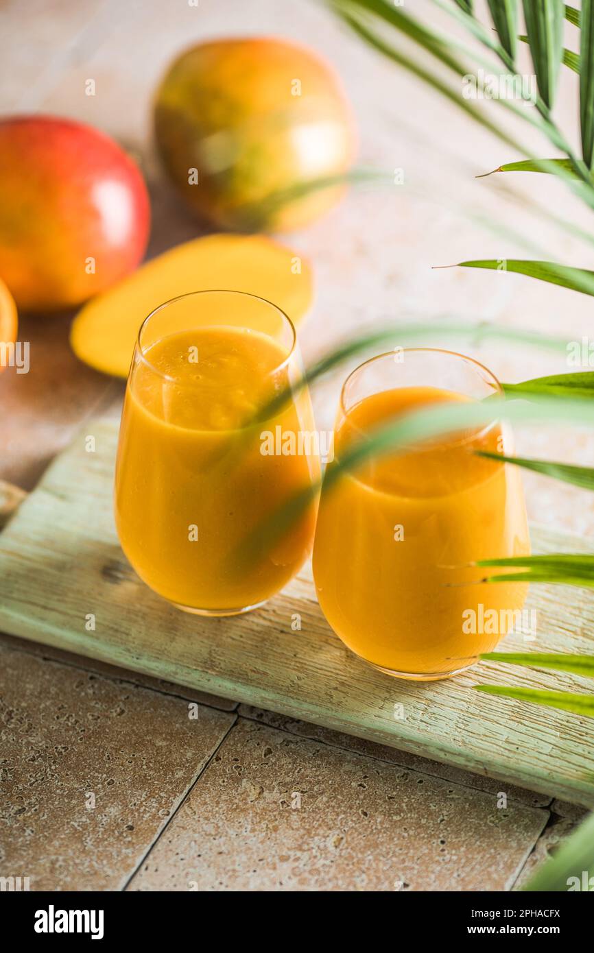 Two mango lassi or kesar milk in glasses. Indian healthy ayurvedic cold ...