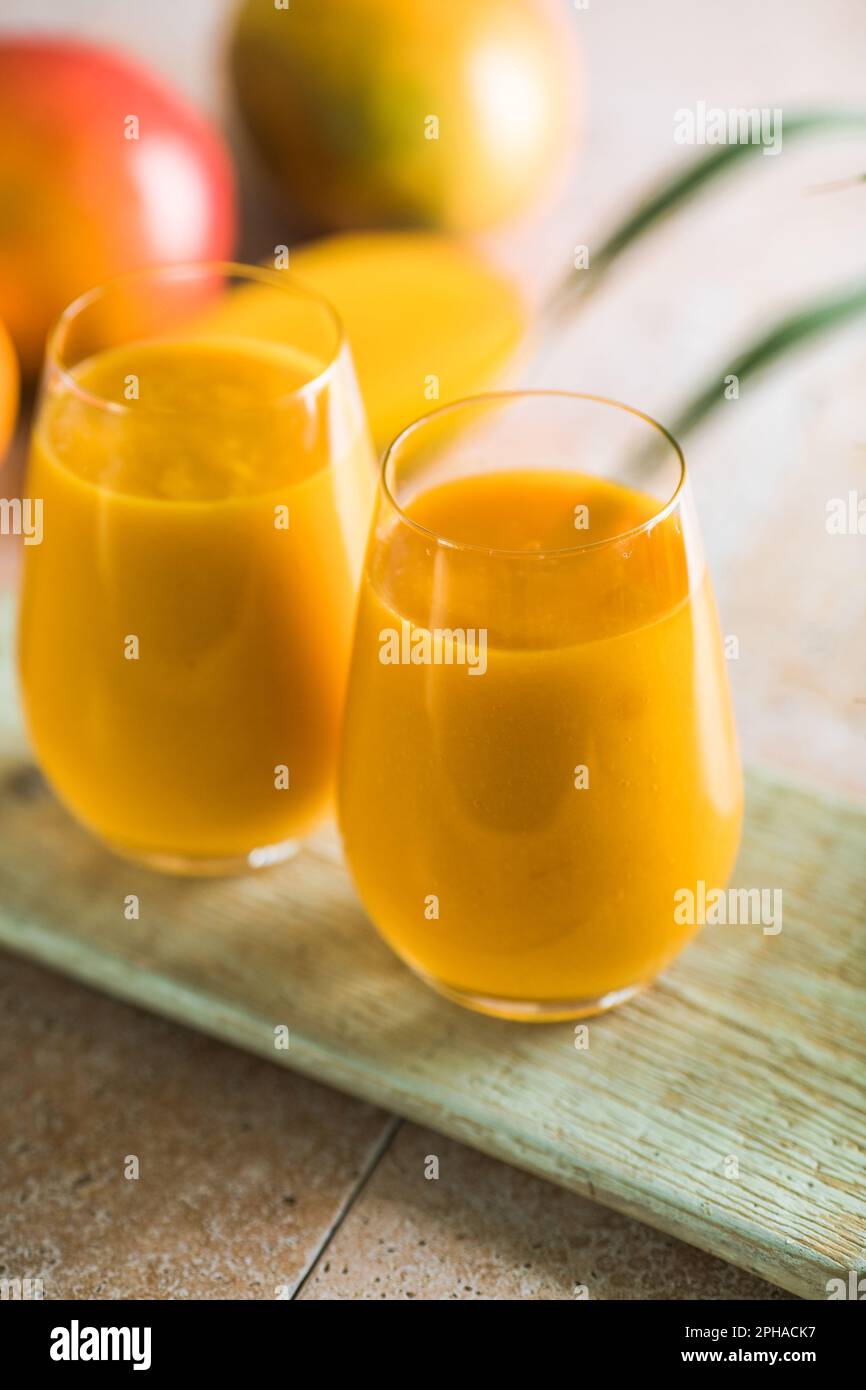 Two mango lassi or kesar milk in glasses. Indian healthy ayurvedic cold ...
