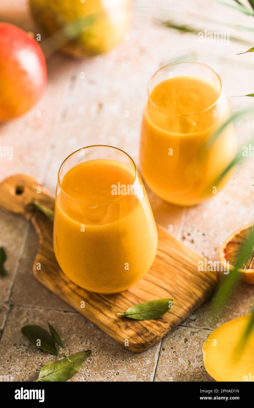 Two mango lassi or kesar milk in glasses. Indian healthy ayurvedic cold ...