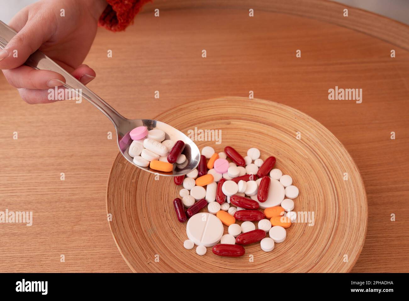 From above of crop anonymous female hand with spoon over round plate ...