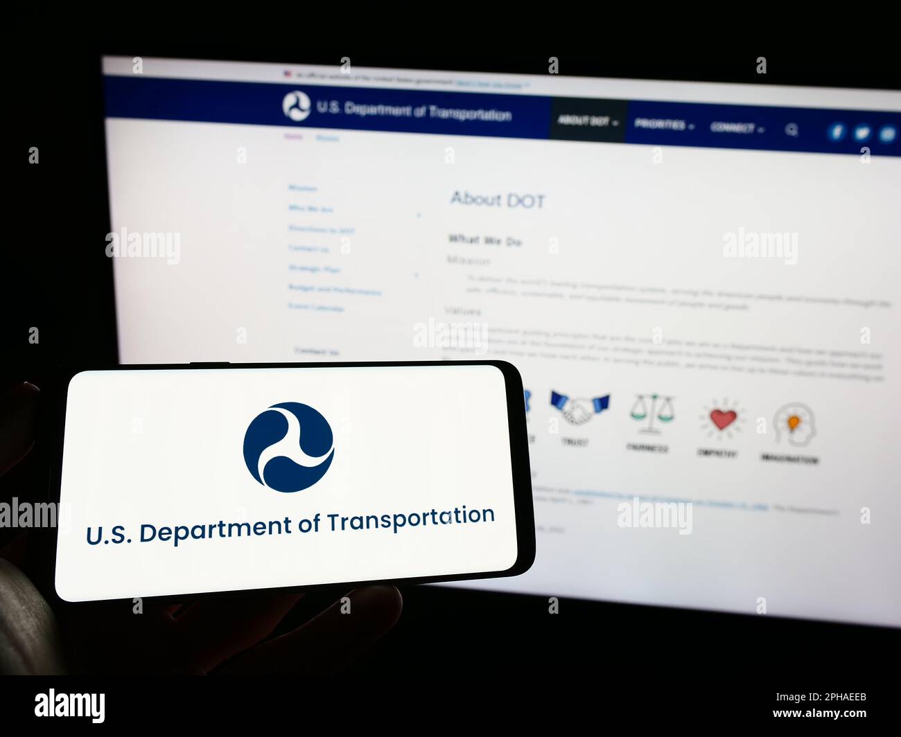 Person holding cellphone with logo of United States Department of ...