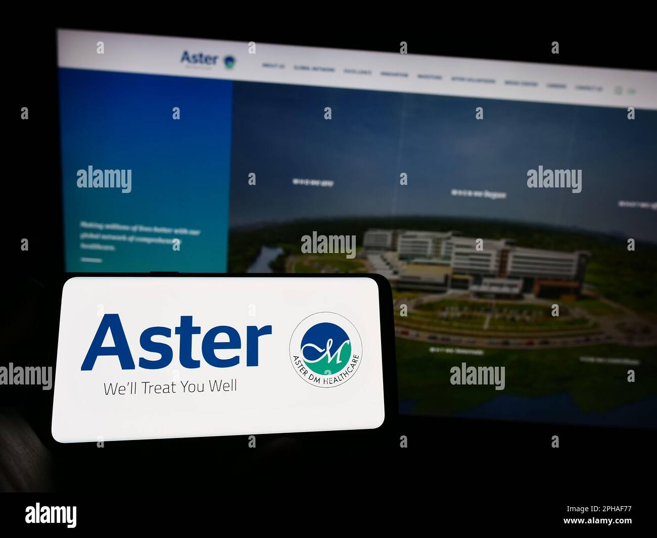 Person holding mobile phone with logo of health company Aster DM Healthcare Limited on screen in ...