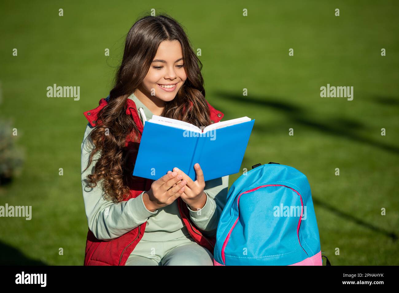 cheerful school teen girl read outside. school teen girl read book Stock Photo - Alamy