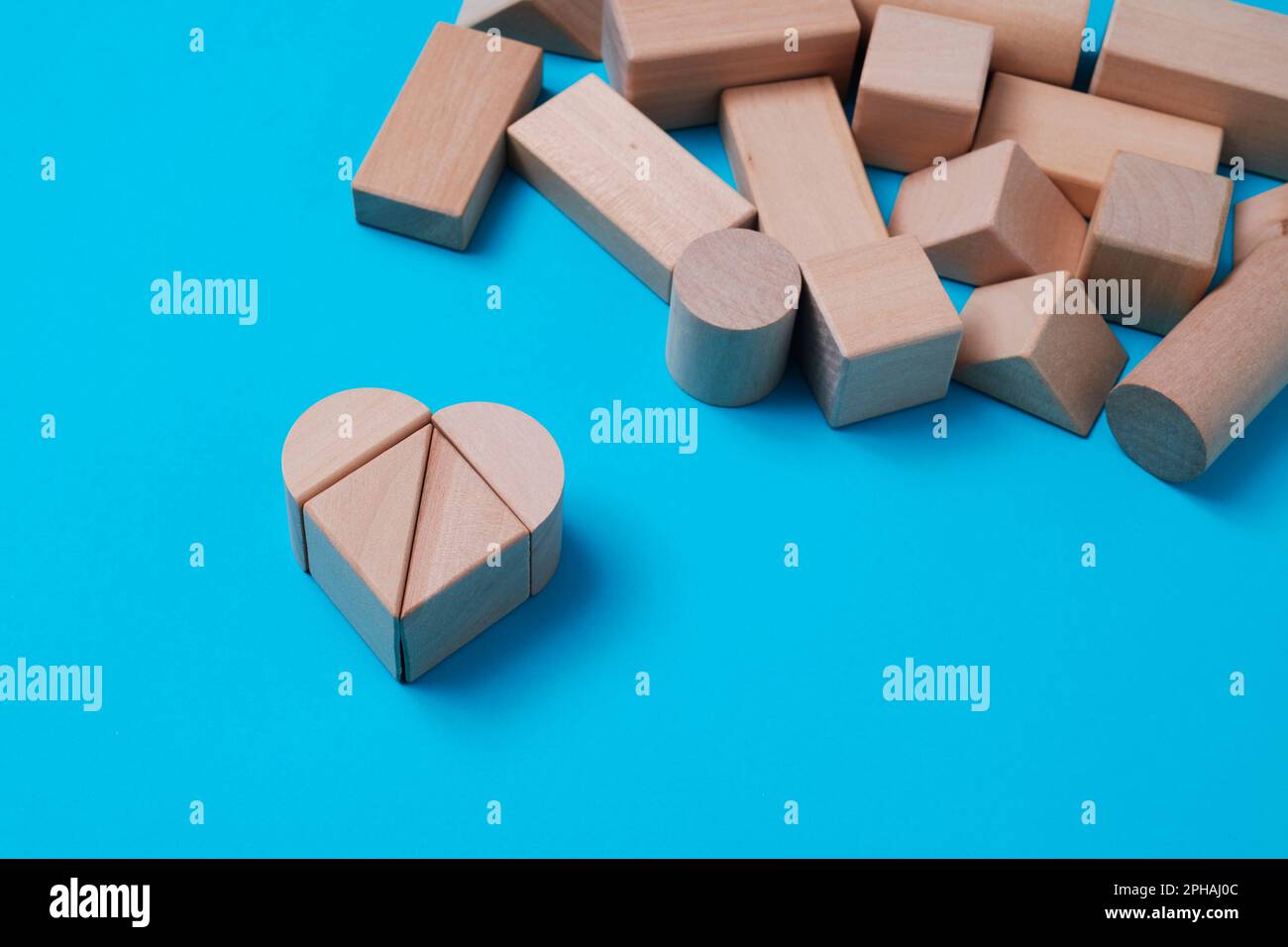 a heart made with some wooden building blocks on a blue background next ...