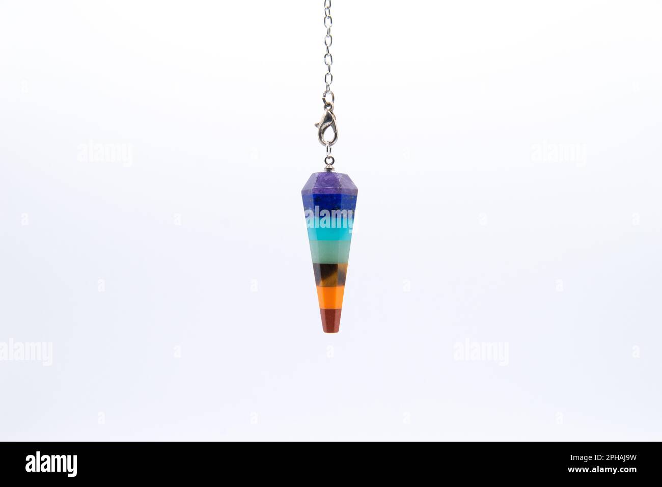 Seven Chakra color crystal pendulum on chain isolated on white ...