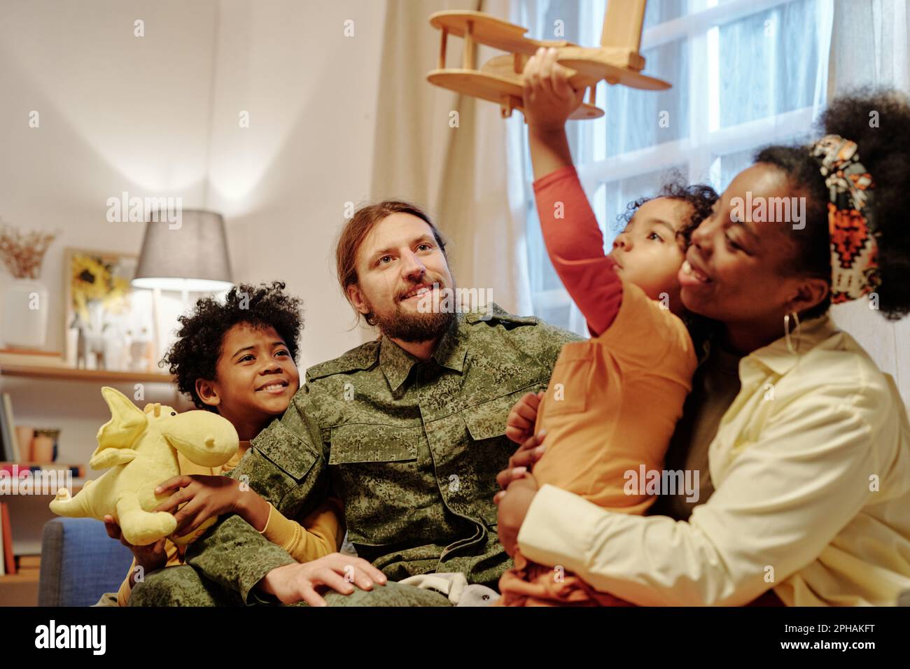 Affectionate intercultural family of four spending time together at ...