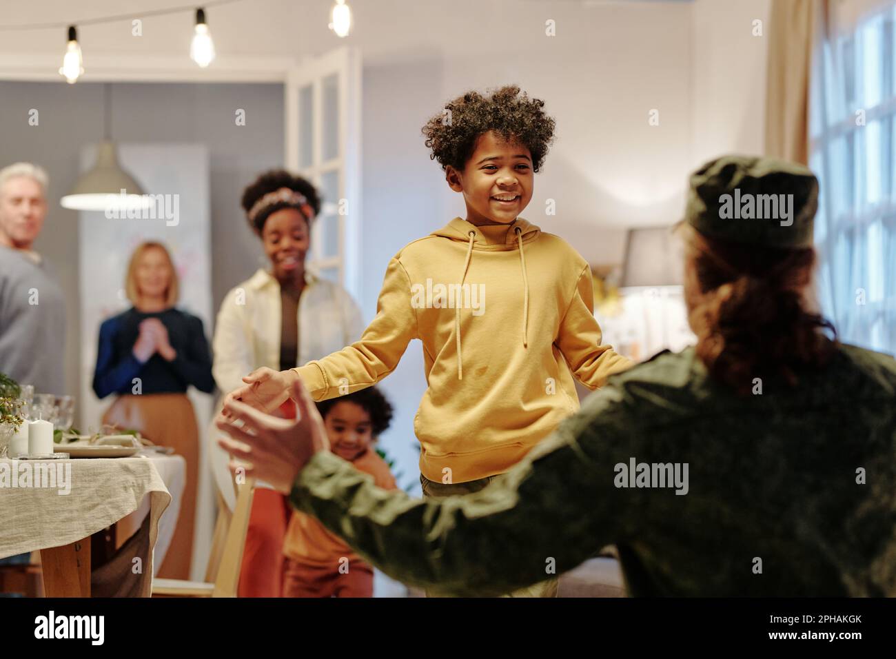 Happy adorable little boy moving towards father in military uniform ...