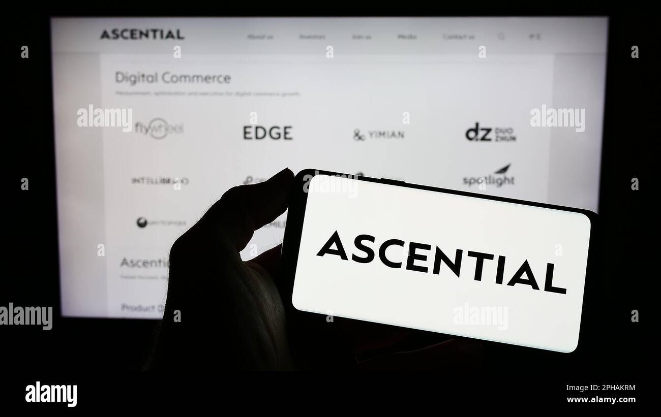 Person holding cellphone with logo of British media analytics company ...