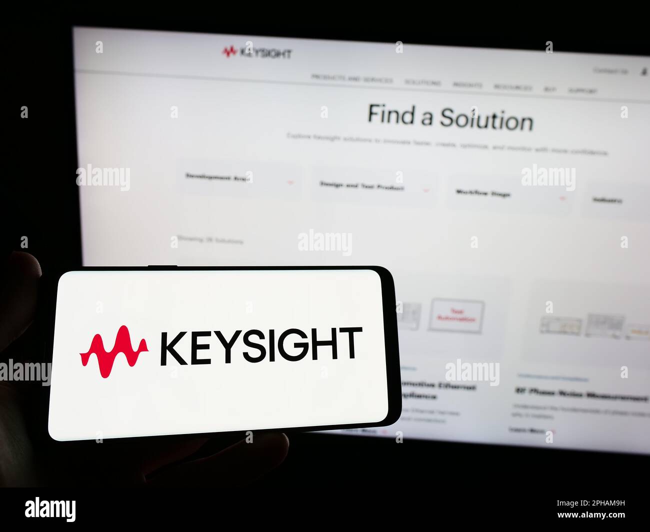 Person holding smartphone with logo of US company Keysight Technologies ...