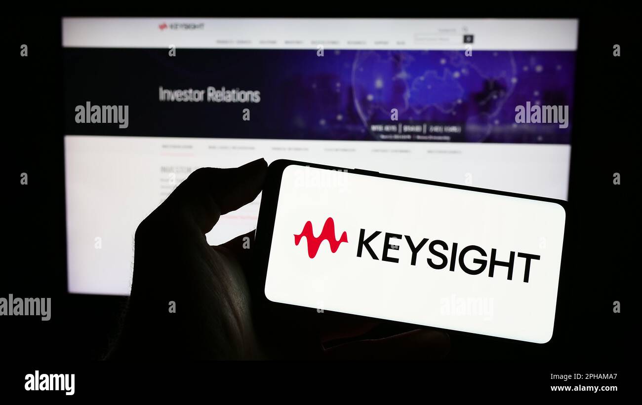 Person holding cellphone with logo of US company Keysight Technologies ...
