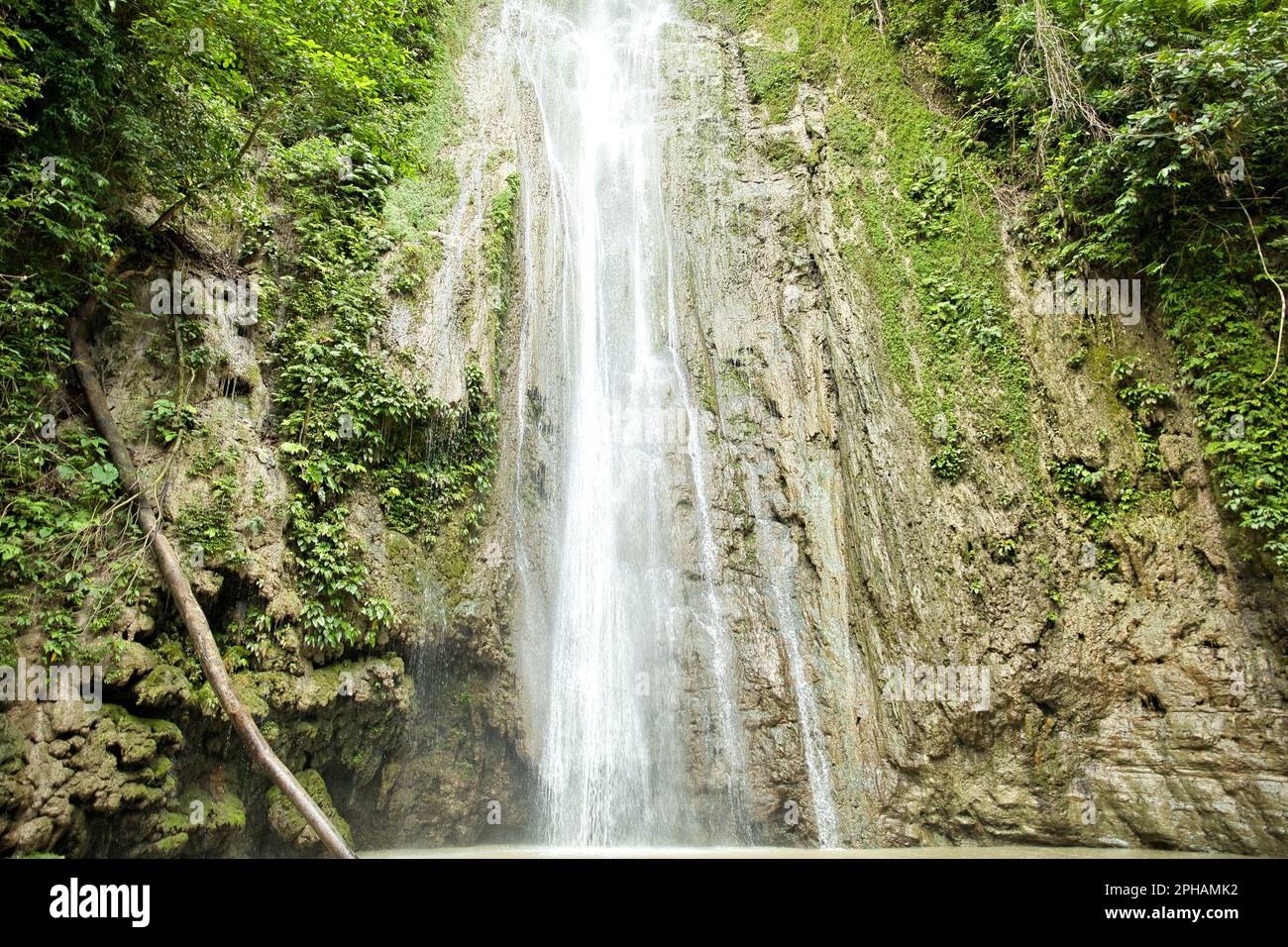 The idyllic Cangbangang Waterfalls in Siquijor in the Philippines surrounded by the light-lit ...